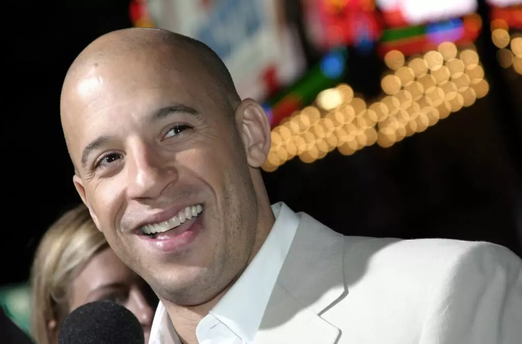 Vin Diesel na premiéře filmu „The Pacifier“ v Los Angeles v béžovém obleku a bílé košili s knoflíky.