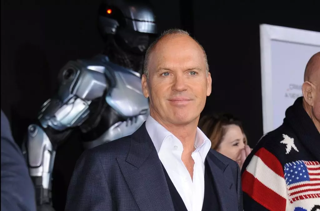 Michael Keaton bei der „RoboCop“-Hollywood-Premiere in einem marineblauen Anzug und einem weißen Hemd mit geöffneten oberen Knöpfen.