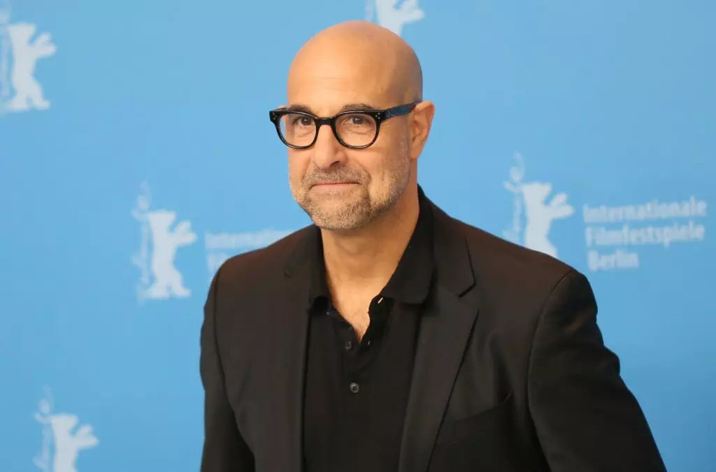 Stanley Tucci na 67. filmovém festivalu Berlinale v černém obleku, černé košili s rozepnutými prvními knoflíky a brýlemi.