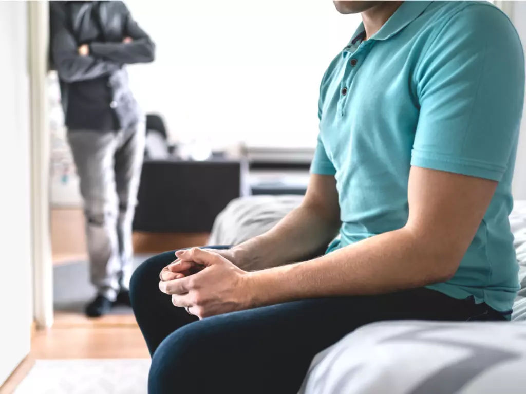 Couple gay en combat. Homme triste en discussion. Amis masculins ou frères en conflit. Stress ou crise dans la relation. Infidélité et tricherie ou jalousie et méfiance. Gars bouleversé assis sur le lit à la maison.