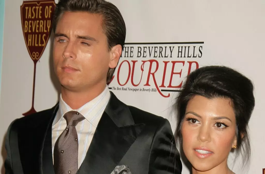 Scott Disick hnav ib lub tsho dub thaum nws coj Kourtney Kardashian, hnav dawb thiab dub, ntawm cov ntaub pua plag liab