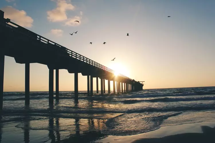 Bilde av San Diego-bryggen over havet ved solnedgang.