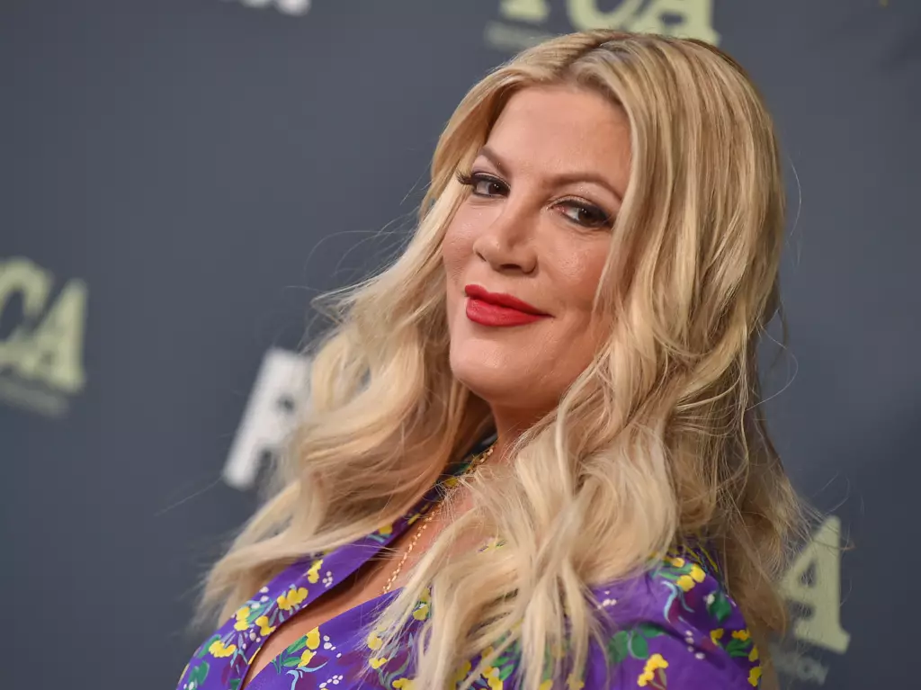 Tori Spelling glimlag vir die kamera