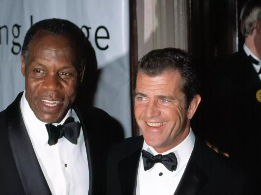 Mel Gibson dhe Danny Glover qëndrojnë së bashku në tapetin e kuq me tufa