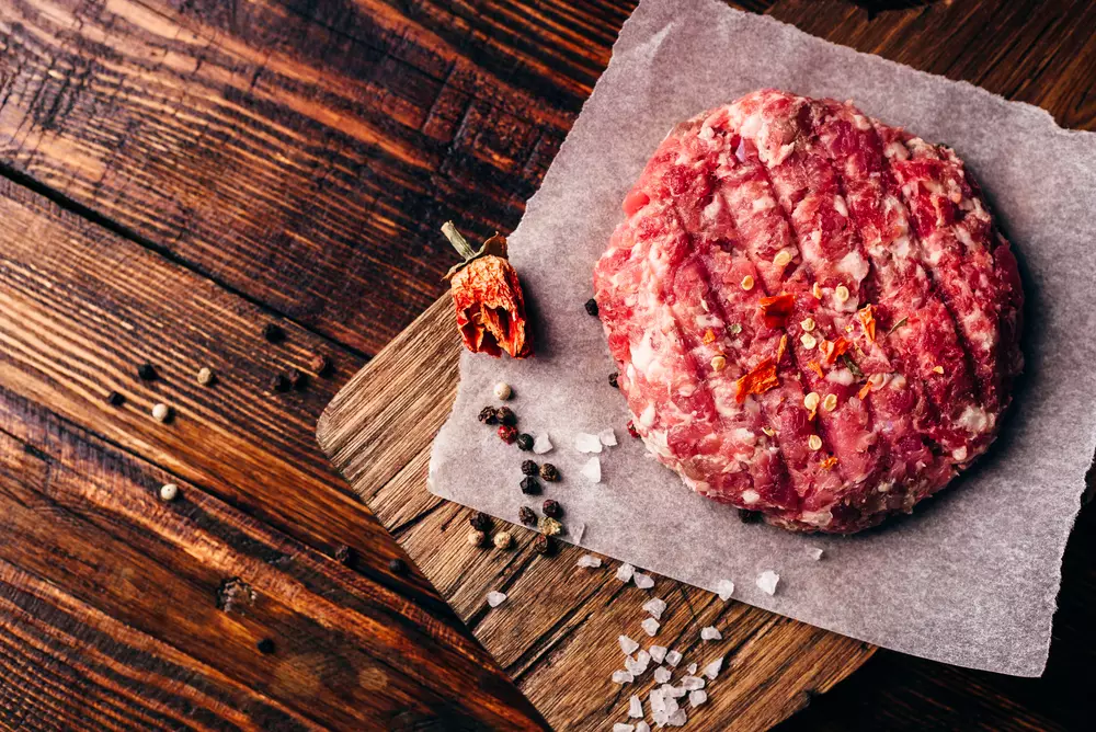 Carne macinata cruda su un pezzo di carta oleata.