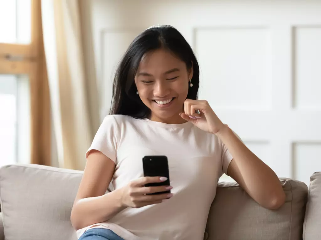 Frau, die auf den Bildschirm des Smartphones schaut