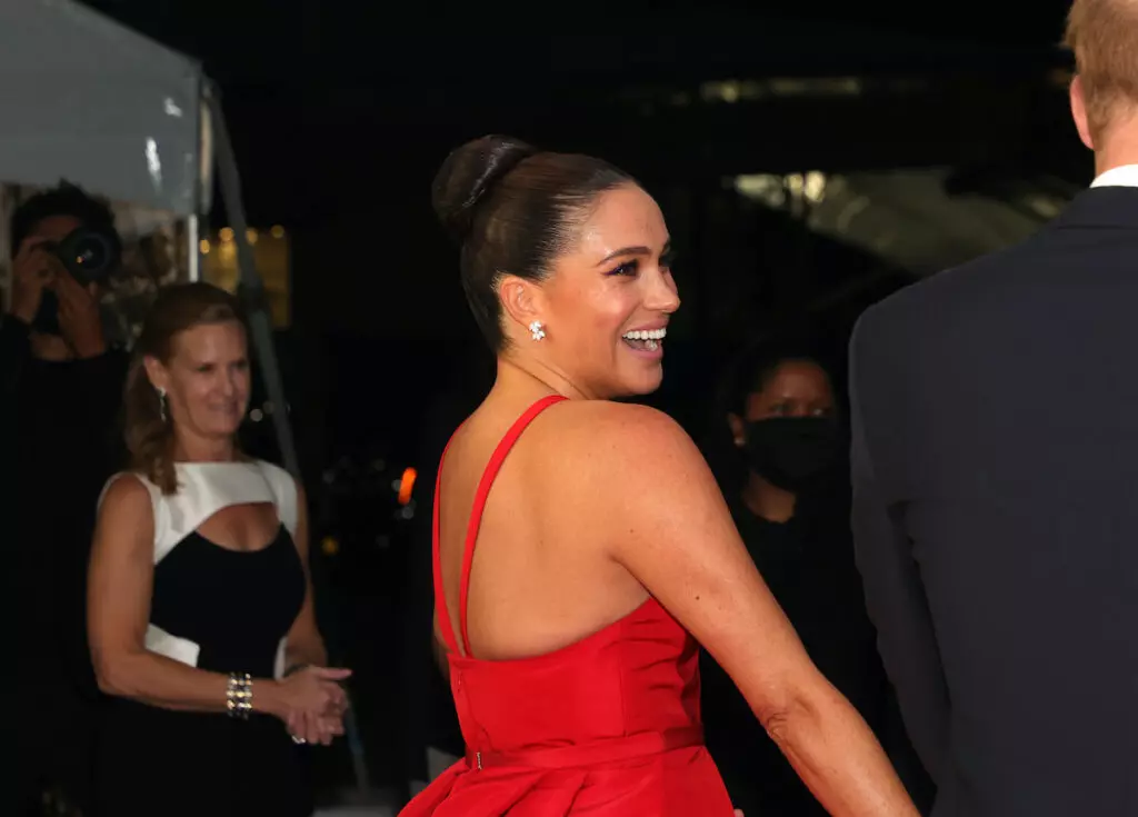 Meghan Markle qırmızı paltarda gülür