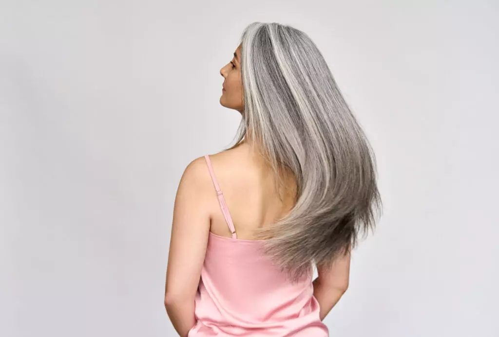 Mujer de espaldas a la cámara con cabello largo y saludable.