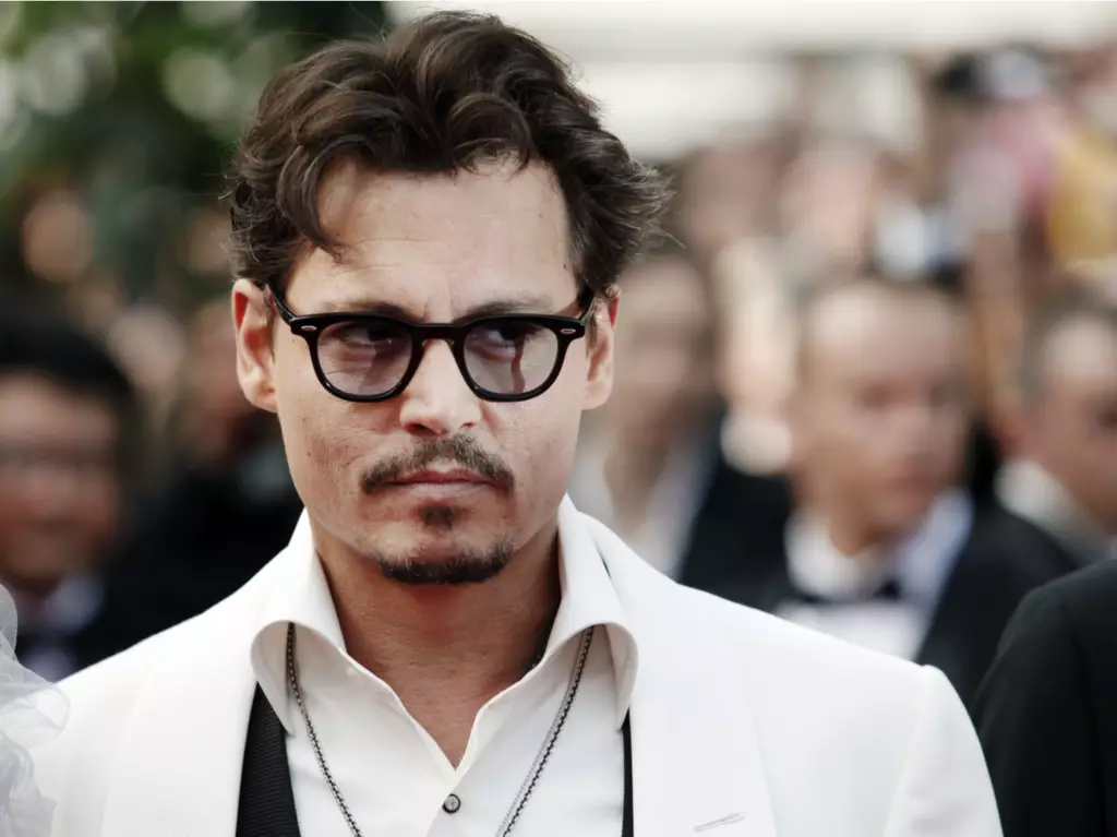 Johnny Depp bär sina svarta glasögon och stökigt utseende